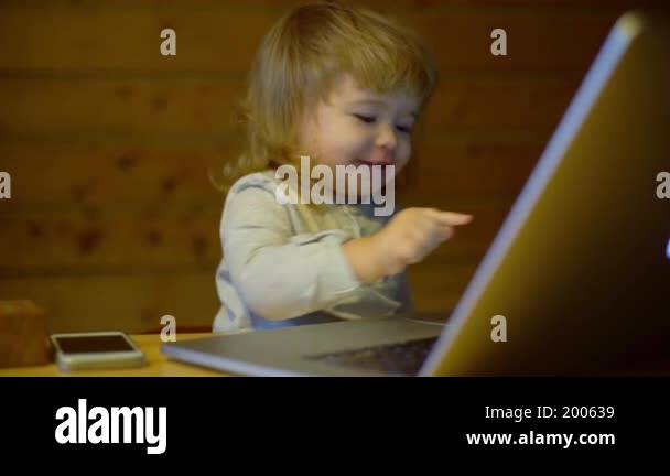 Baby with laptop. Blond baby working with laptop at home. Smart little ...