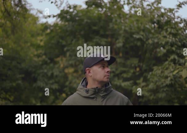 a vertical shot of a handsome man with a beard and a cap posing in the ...