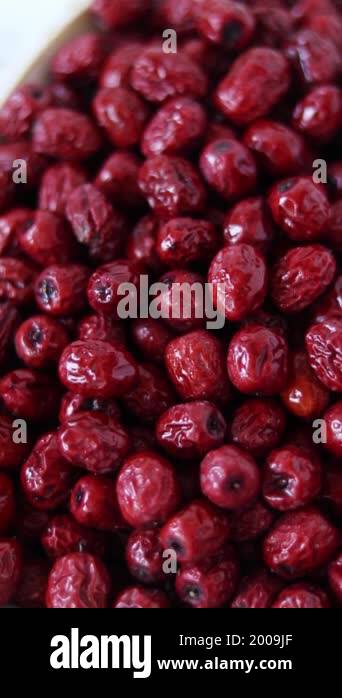 Red Chinese dates (jujube) rotating in a plate on white background ...