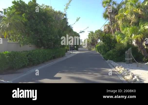 Driving on scenic road in sunny Florida. Casey Key coastal residential ...