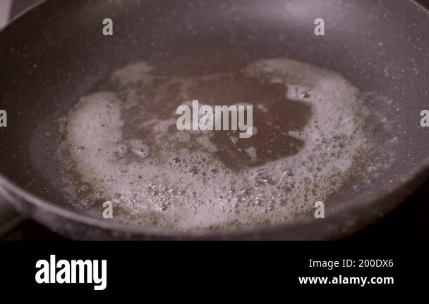 Butter slowly melting deliciously in a sizzling frying pan, creating a ...