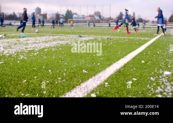 Bokeh effect of children training in winter. Soccer players diligently ...