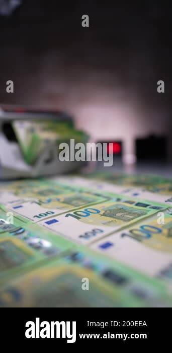 One hundred euro bills laid out on the desk. Cash counting machine ...