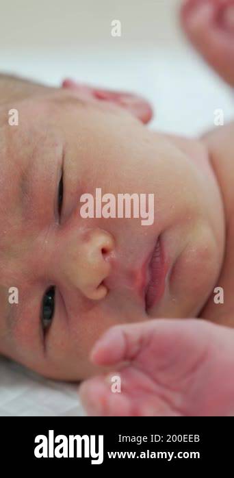 Infant hiccups. Newborn baby boy laying on hospital table. Side ...