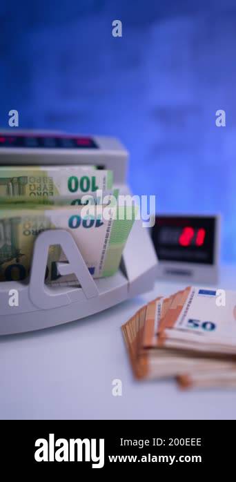 Euro banknotes being counted in cash counting machine. Fifty euro stack ...