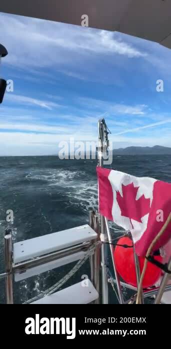Video footage of a Canadian flag blowing in the wind on a sailboat on ...