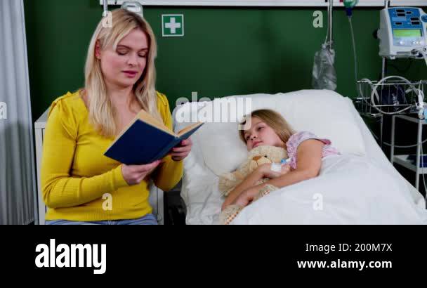 A loving caregiver reads a heartwarming story to a child in a hospital bed, fostering joy and ...