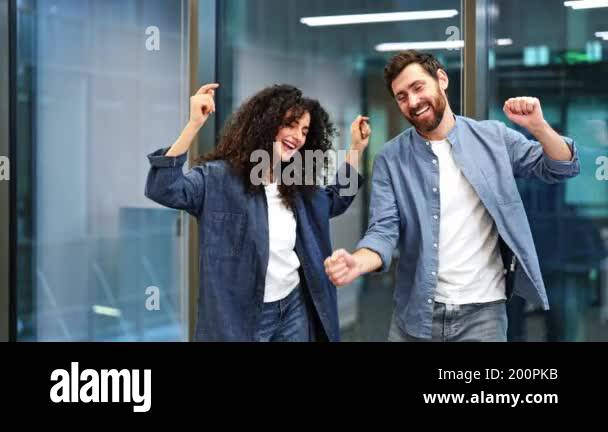 Joyful business colleagues dance together, celebrating success in a ...