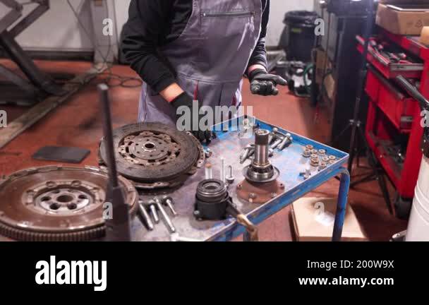 Professional car mechanic carefully assembling automotive parts with ...