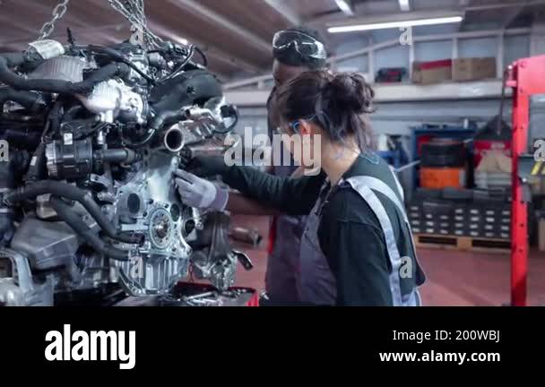 Professional mechanics in safety gear collaborating while inspecting ...