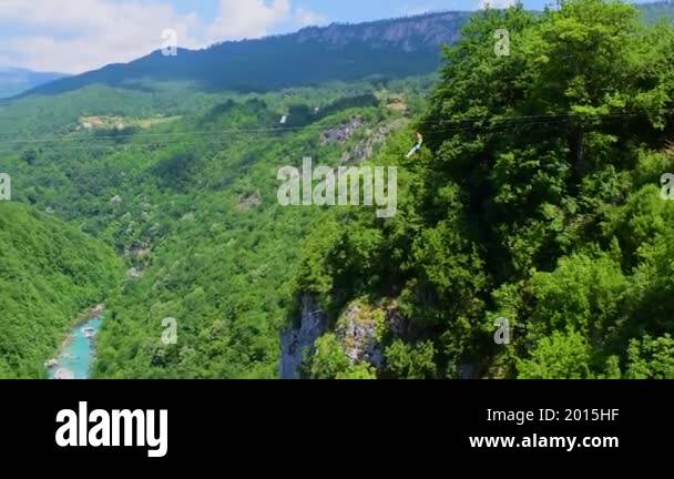 Tourist rides on a zipline over the Tara River Canyon or Tara River ...