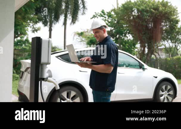 Qualified technician working on home EV charging station installation ...
