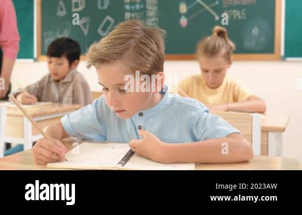 Attractive caucasian boy looking at camera while studying math at ...