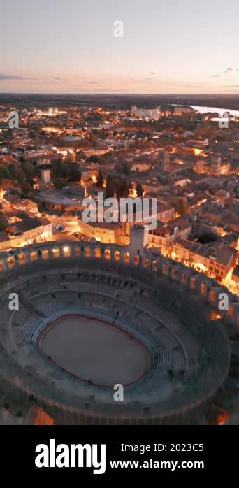 Cityscape of Arles at night, southern France. HIstoric buildings, Arles Amphitheatre and Rhone ...