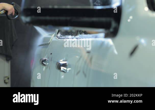 Car Detailer Washing with a Water High Pressure Washer. Professional ...