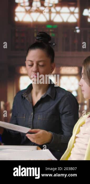 Vertical Video Female mentor providing instruction to diverse pupils ...