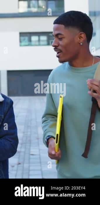 Vertical HD video of two multiracial young college students hanging out ...