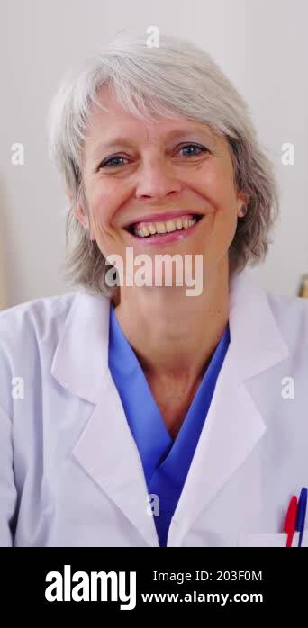 Vertical HD portrait of female mature healthcare worker smiling at ...
