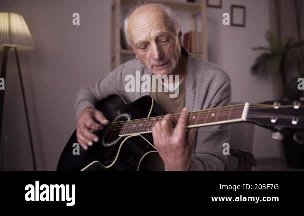 Retired man play guitar and composing, create new song using musical ...