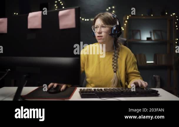adult female gamer with glasses playing a round in online video game on ...