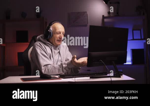 elderly pensioner man playing online games using pc gaming setup having ...