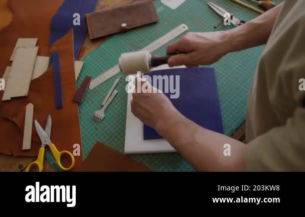 High angle shot of unrecognizable craftsman using mallet and chisel to ...