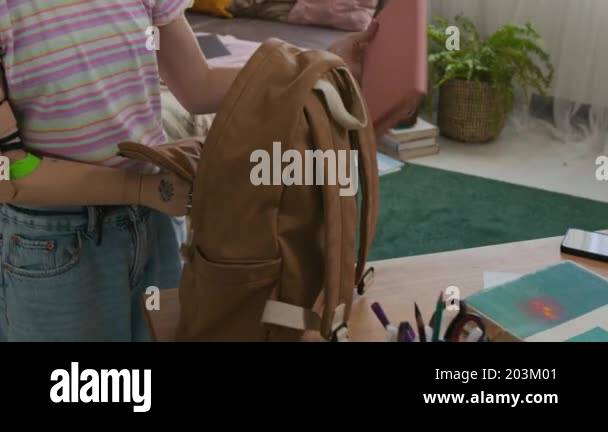 Teenage girl with disability wearing casual clothes putting pink ...