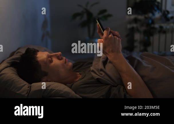 Man using phone late at night in bed, causing frustration and sleep ...
