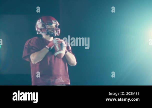 An American football player practicing throwing and catching the ball ...