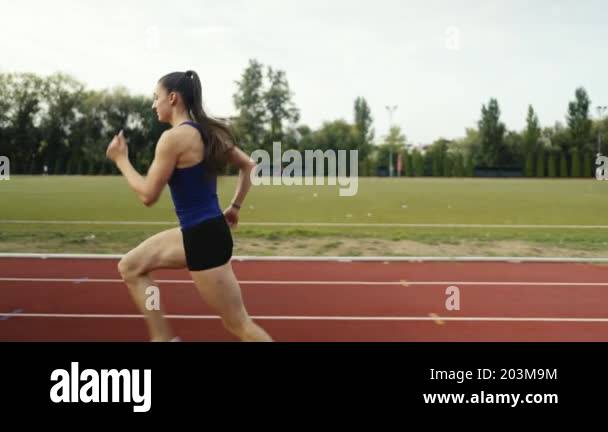 professional female athlete practicing running on a large stadium ...