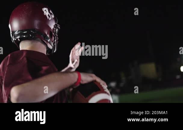 An American football player practicing throwing and catching the ball ...