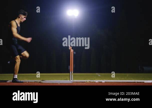 Strong Male Athlete is Running Towards an Obstacle, Hurdling, Jumping ...