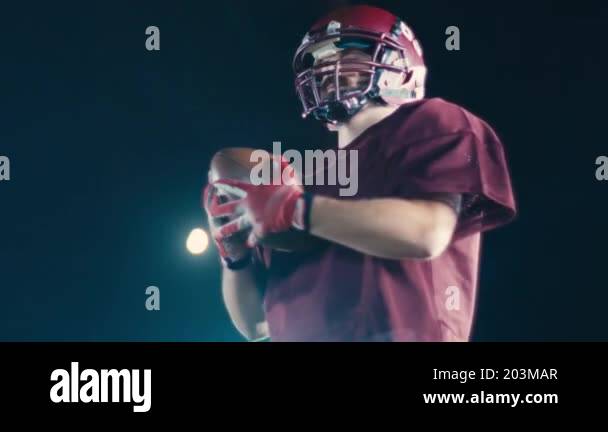 An American football player practicing throwing and catching the ball ...