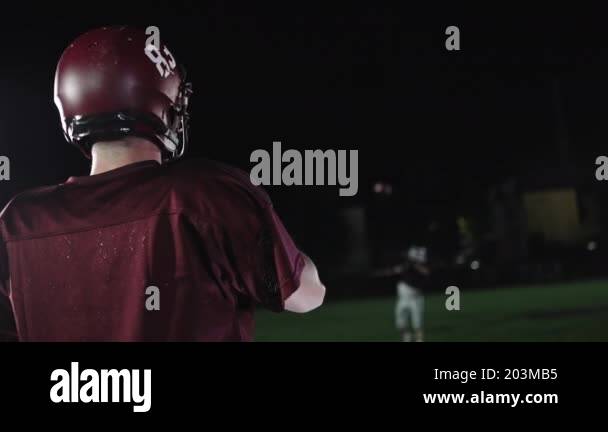 An American football player practicing throwing and catching the ball ...
