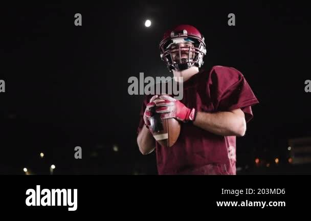 An American football player practicing throwing and catching the ball ...