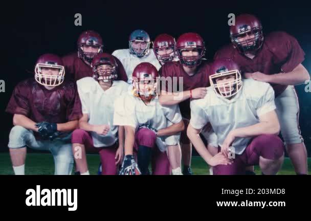 A group of American football players wearing maroon and white uniforms ...