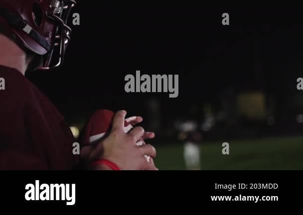 An American football player practicing throwing and catching the ball ...