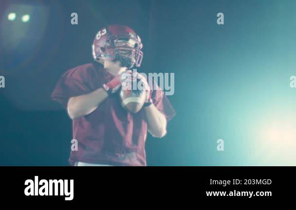 An American football player practicing throwing and catching the ball ...