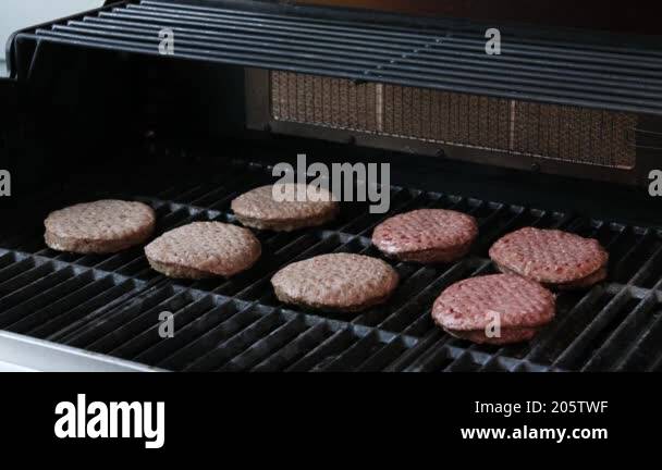 Cooking beef patties for burgers. Slow motion. Hamburger patties are ...