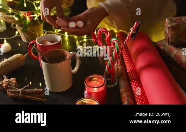 Festive scene with hot cocoa, candy canes, and marshmallows amid ...