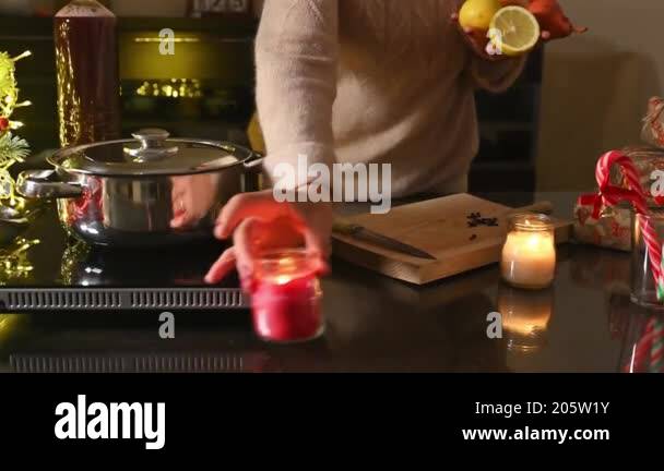 A cozy kitchen setting with candles, fresh fruits, and a cooking pot ...
