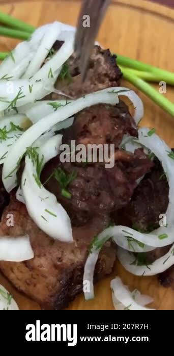Close-up shot of a mans hands dipping a piece of grilled meat into a ...