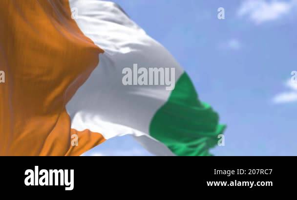 Ivory Coast national flag waving in the wind on a clear day. Three ...