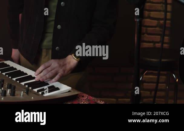 Pan shot in a recording studio with a pianist playing a digital ...