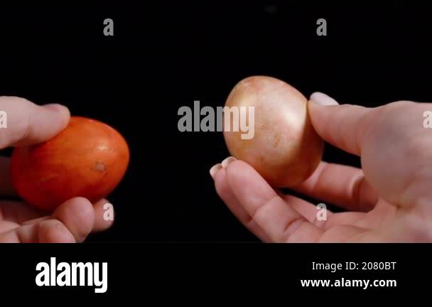 Hands hold two Easter eggs, ready to tap them together in a traditional ...