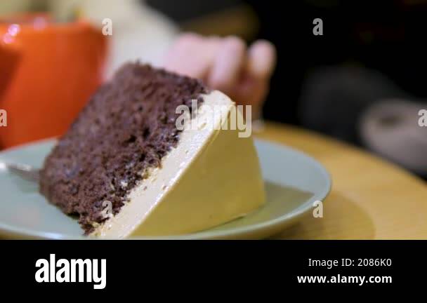 Close-Up of Chocolate Cake Slice Being Spooned on a Plate, Creamy Sauce ...