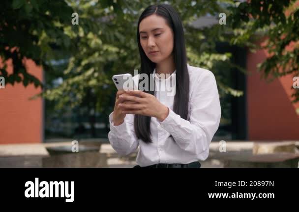 Asian Korean Chinese woman user mobile phone smartphone texting ...