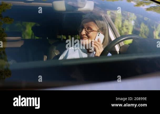 Laughing cheerful Caucasian elderly business woman car taxi driver auto ...