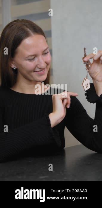 Young woman sitting on sofa, expressing excitement and joy while ...