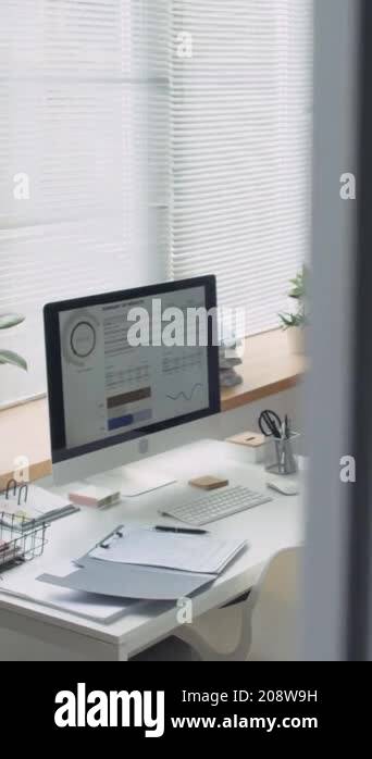 Vertical shot of office workplace with papers, stationery and desktop ...